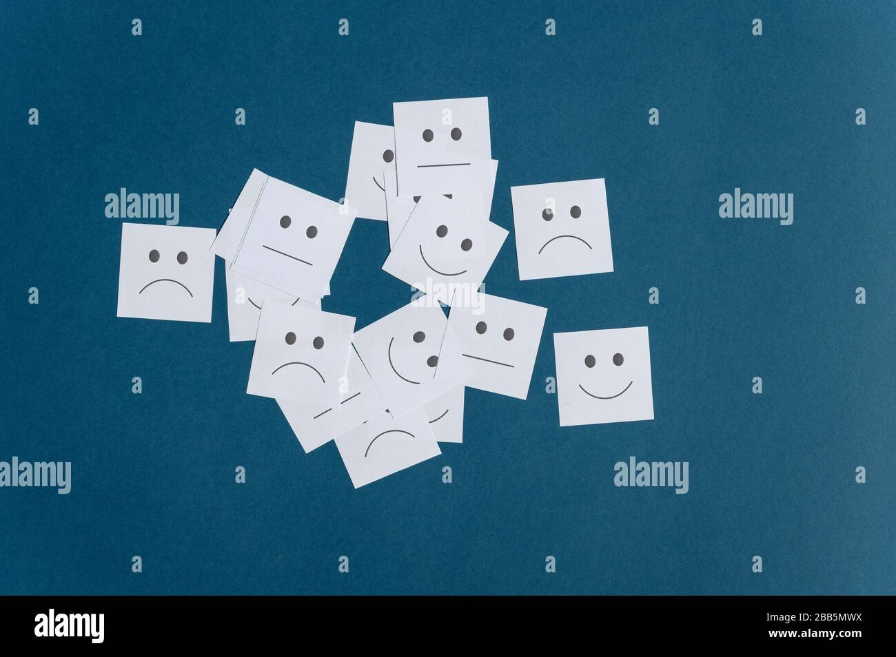 Many white post it papers with smiling sad and neutral faces on them ...