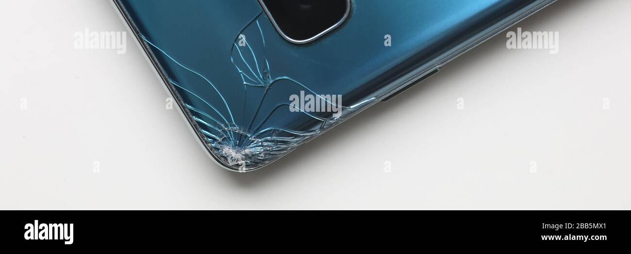 Modern smartphone lying at table with crack in corner Stock Photo - Alamy