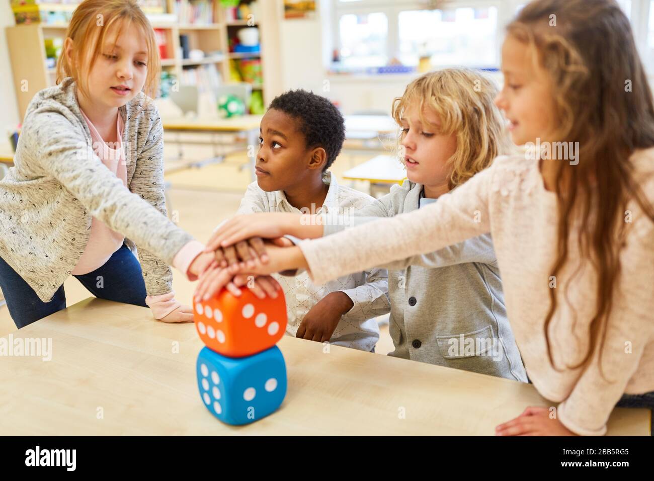 Group of children stacks hands as a team concept in the classroom Stock ...