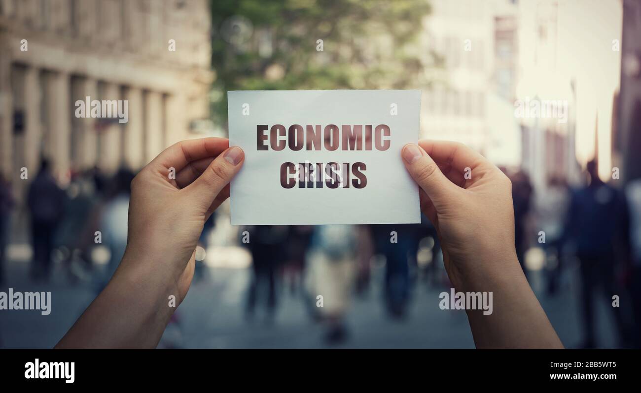 Hands holding a paper sheet warning about the global economic crisis ...