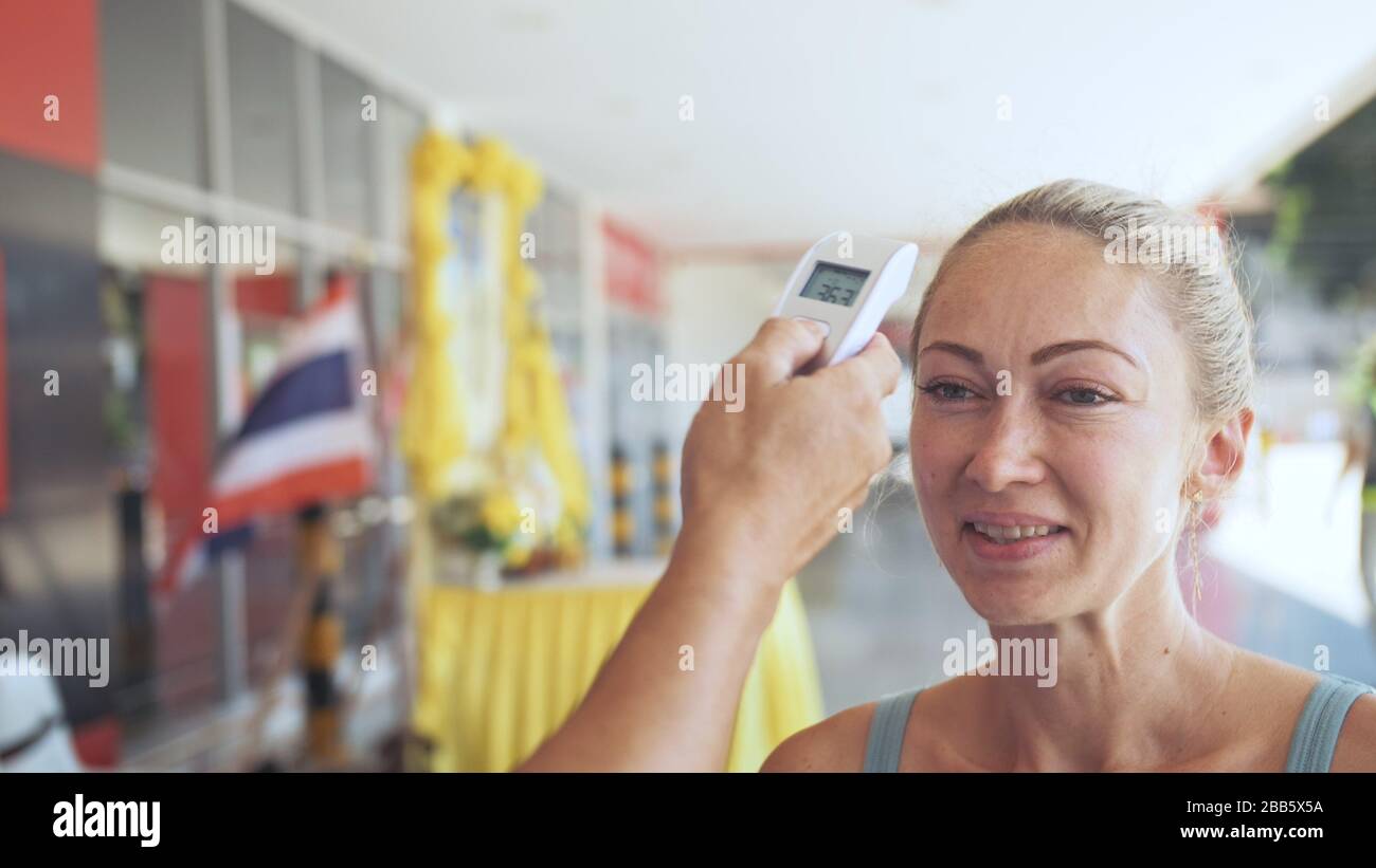 Temperature check at a supermarket of woman, grocery store with thermal ...