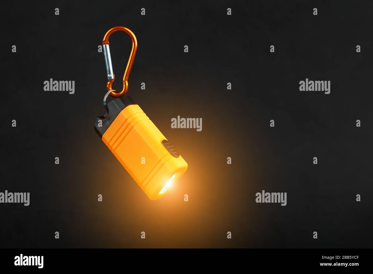 Orange led Flashlight with a carabiner on a black background. LED ...