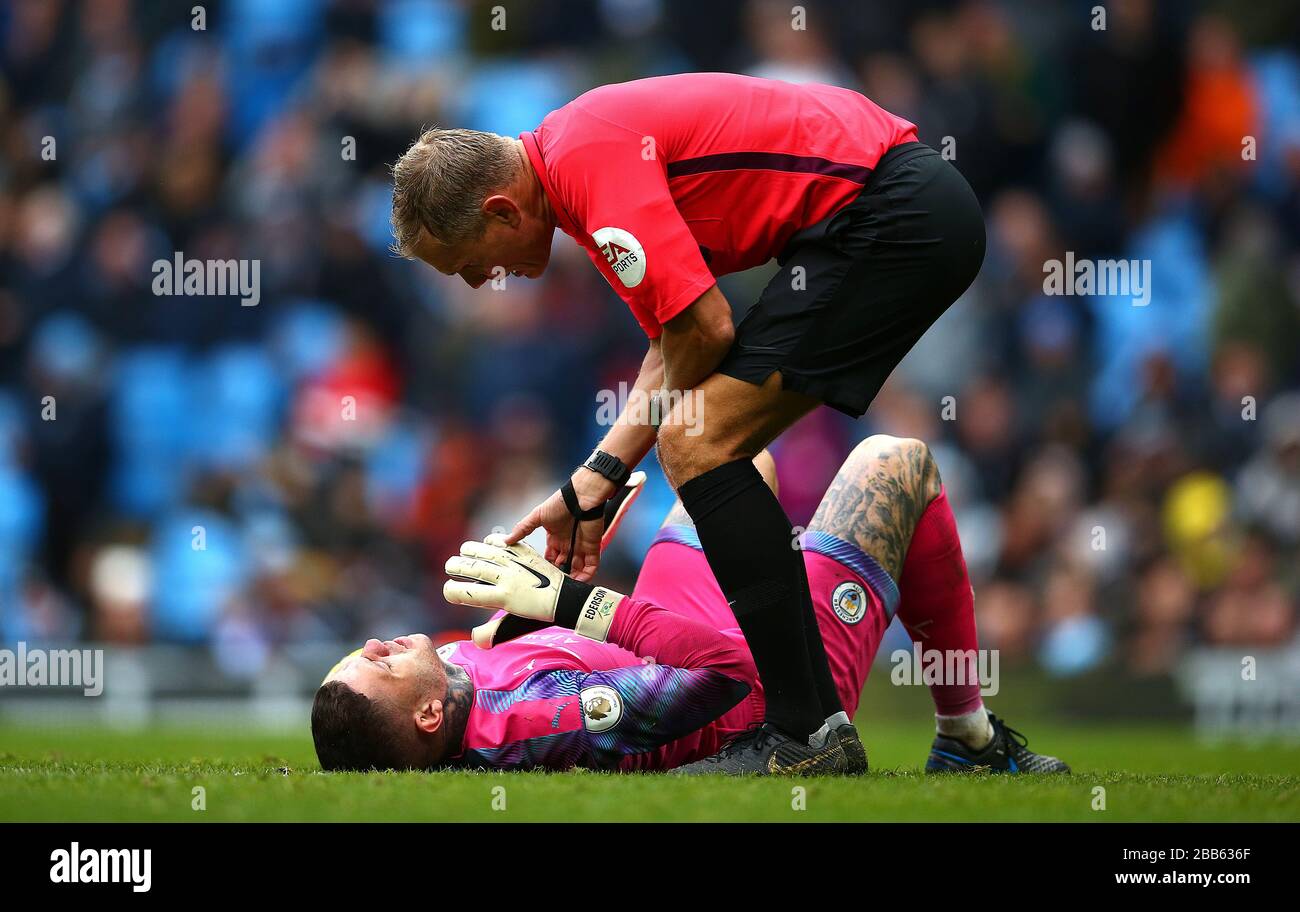 Manchester City goalkeeper Ederson on the ground after picking up an ...
