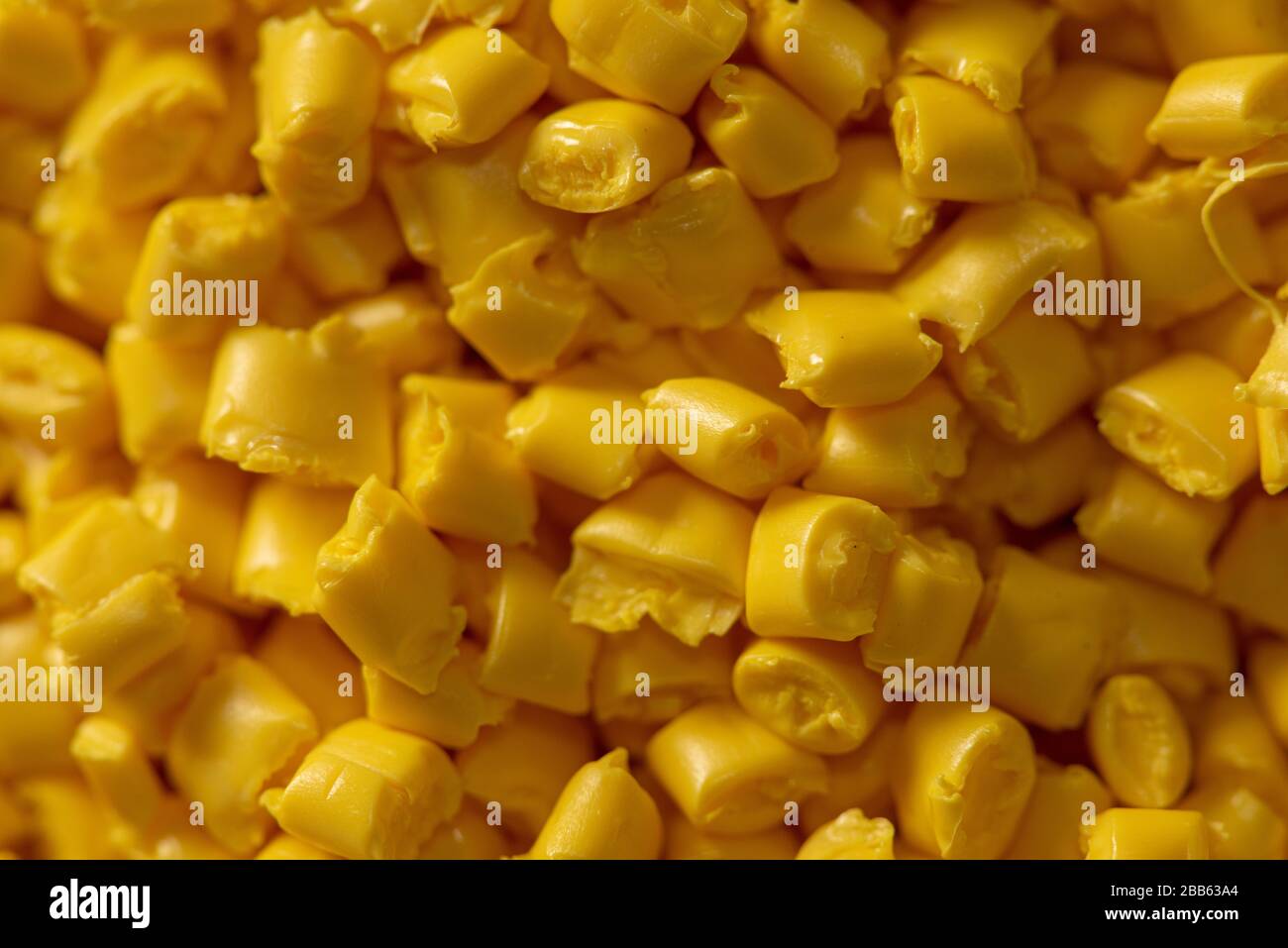 Granular recycled yellow plastic Stock Photo - Alamy
