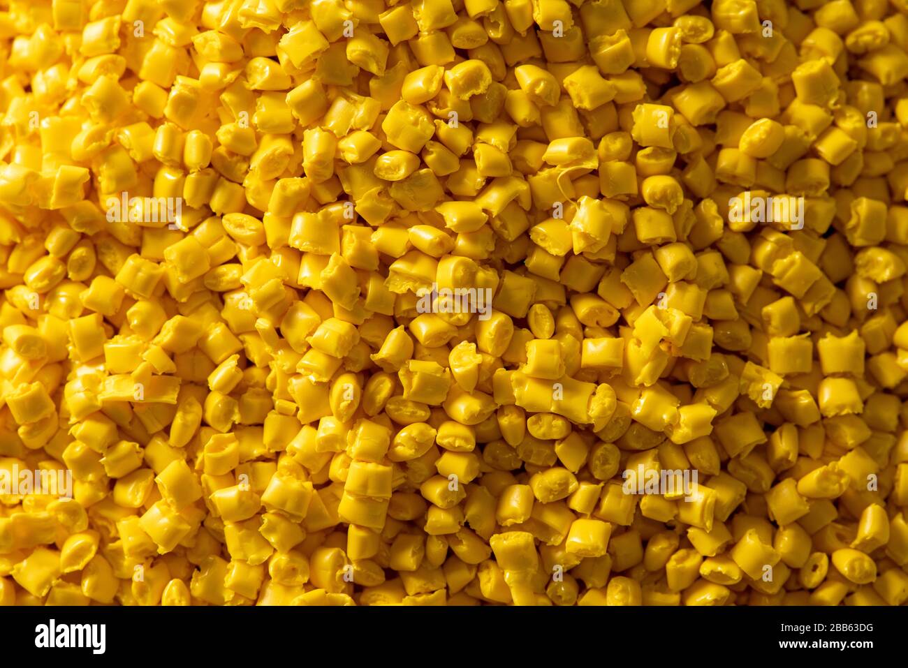 Granular recycled yellow plastic Stock Photo - Alamy