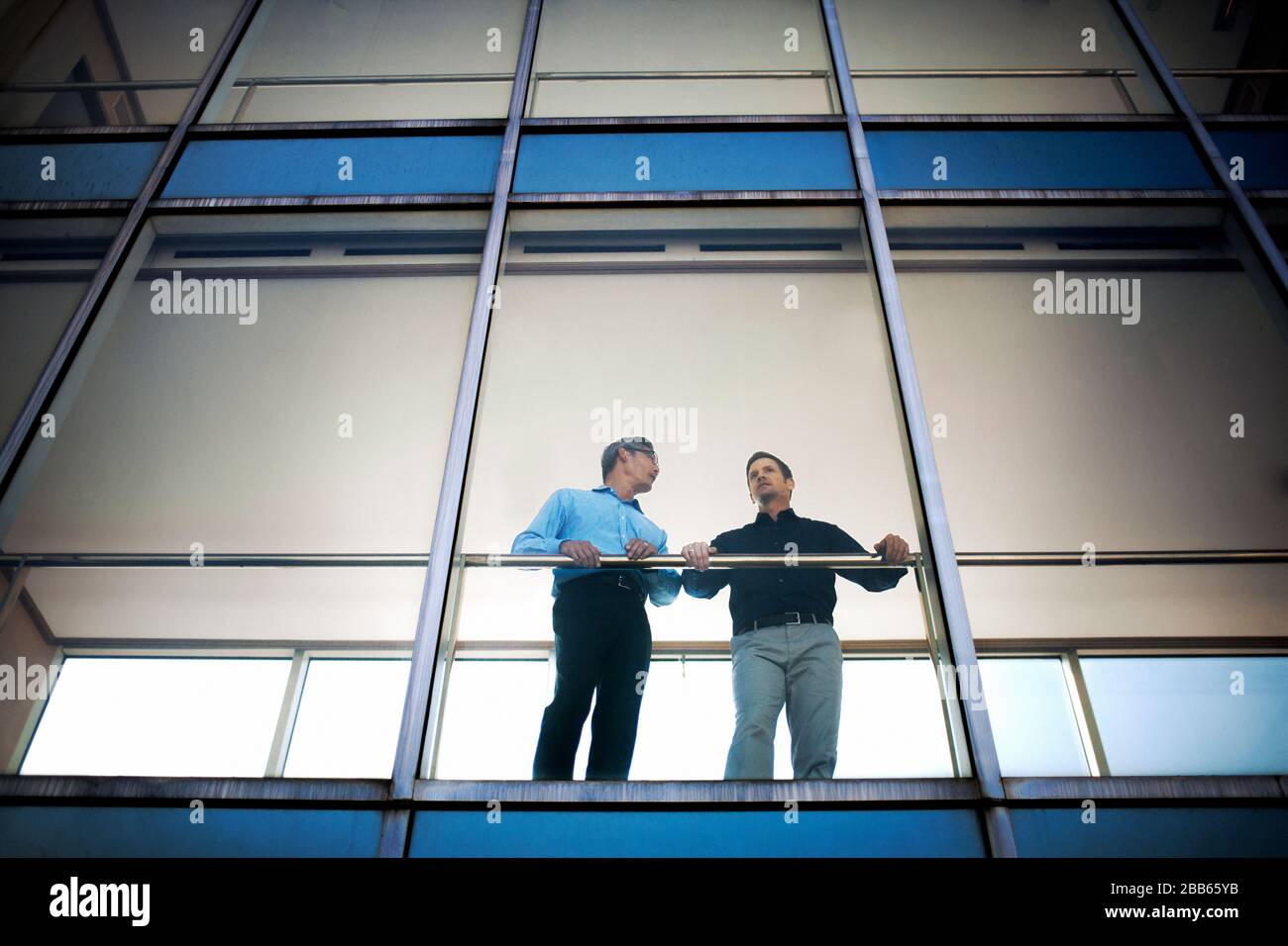 Businessmen looking out at the view from their office building Stock ...
