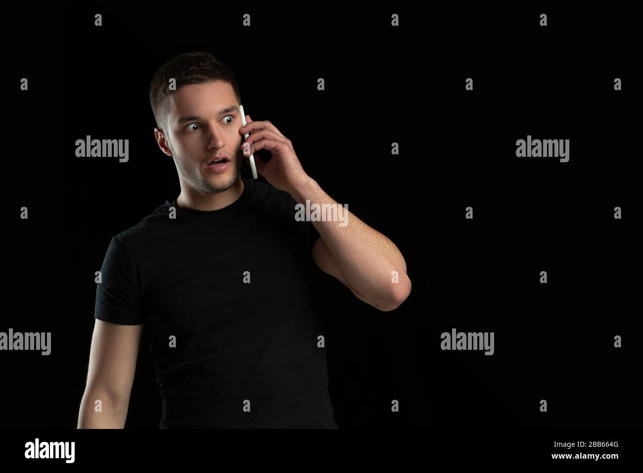 Talking on phone. Monochrome portrait of young caucasian man isolated ...