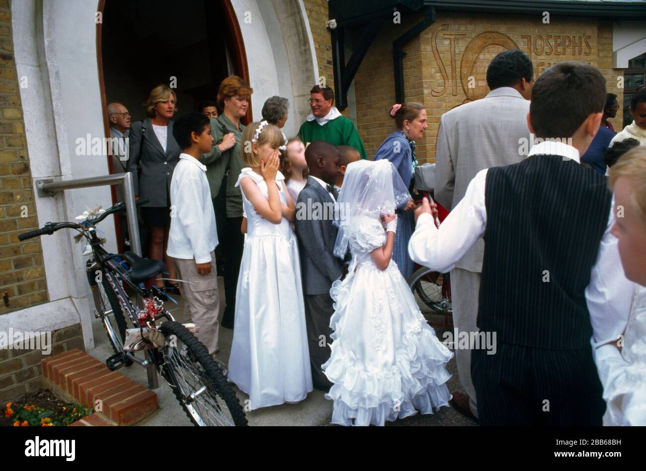 St Joseph's Church Children & Priest Outside Church Roehampton Stock ...