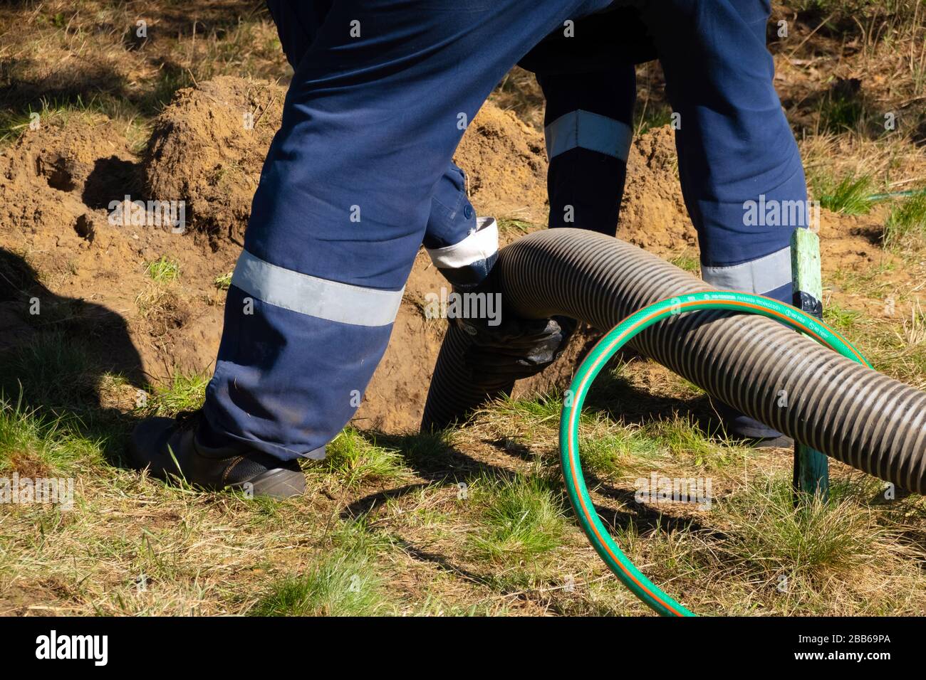 Man worker holding pipe, providing sewer cleaning service outdoor ...