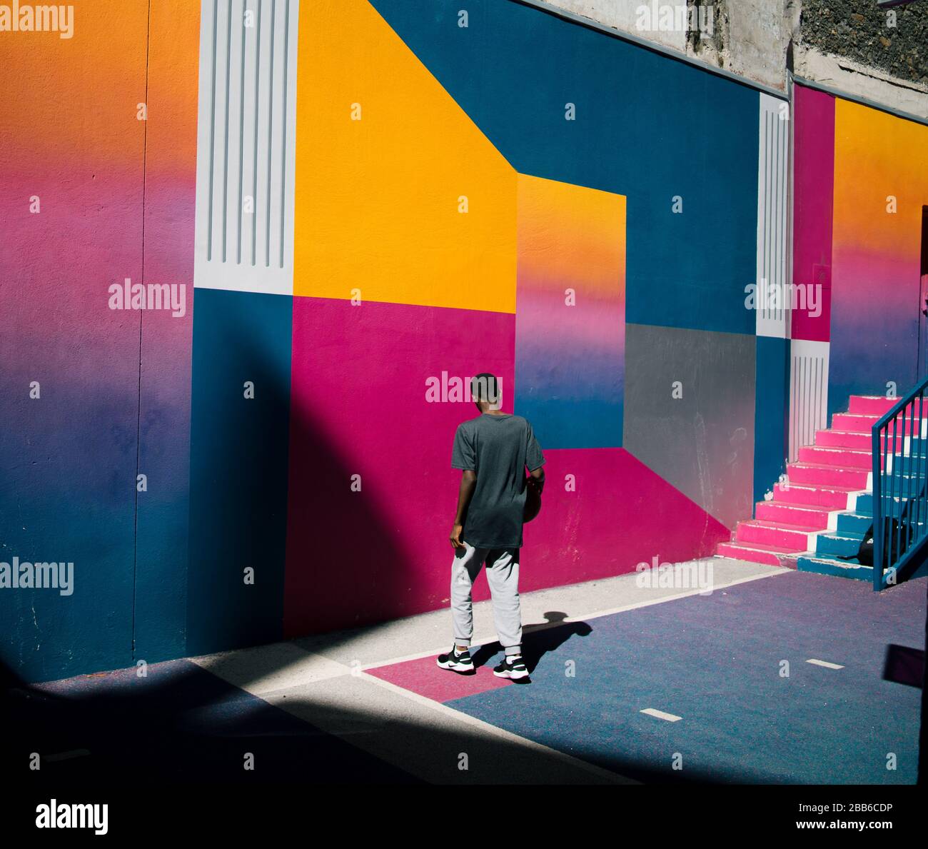 Dark Skin kid playing basketball in colorful court in Paris Stock Photo ...