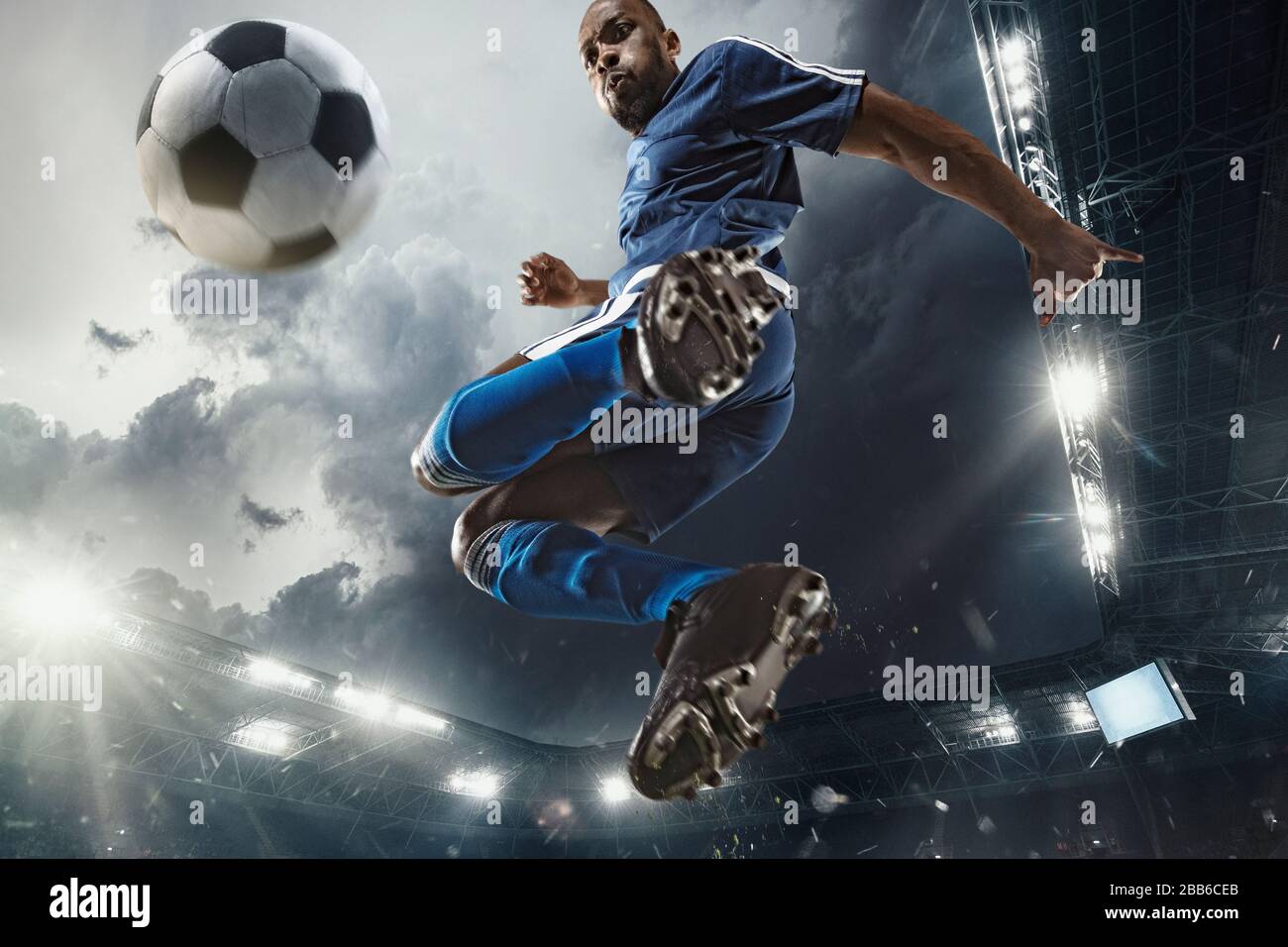 Professional football or soccer player in action on stadium with ...