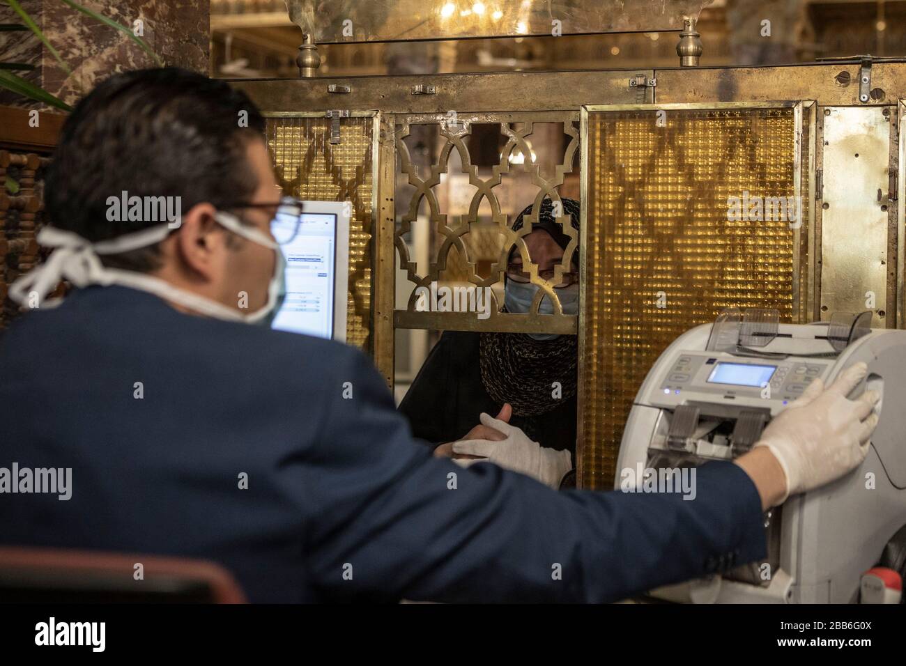 Cairo, Egypt. 30th Mar, 2020. An employee wearing a face mask serves a ...