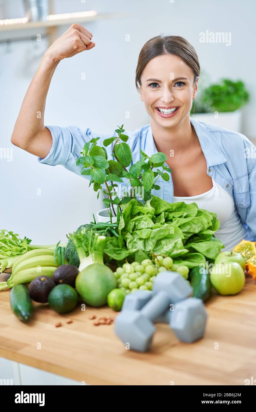Healthy adult woman with green food in the kitchen Stock Photo - Alamy