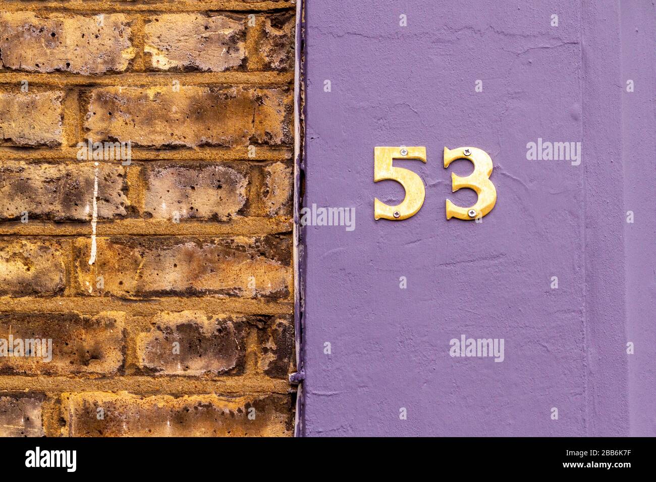 House number 53 on purple next to brick Stock Photo - Alamy