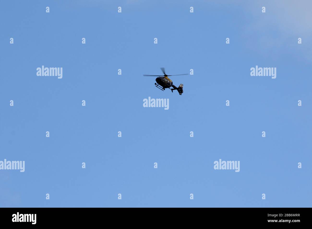 Police helicopter hovering over London with a blue sky and white cloud ...