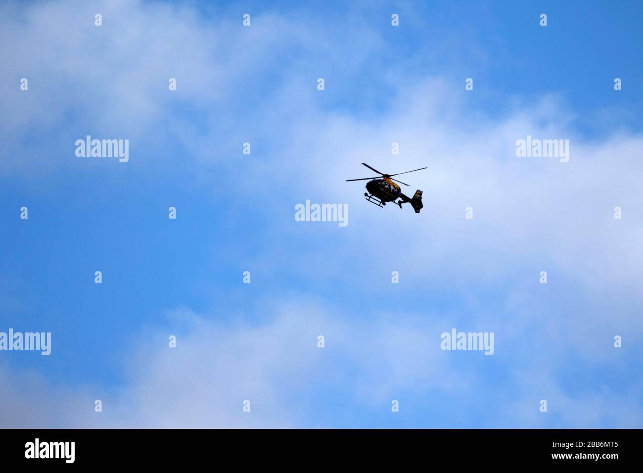 Police helicopter hovering over London with a blue sky and white cloud ...