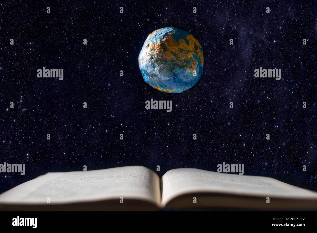an open book, a levitating model of the planet earth levitates above it ...