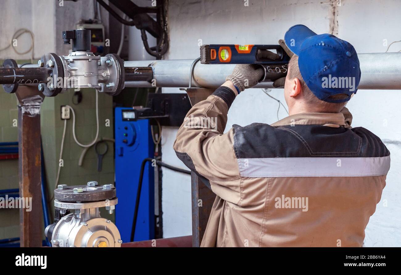 Fitter assembler is assembling a new gas pipeline line in a gas boiler ...