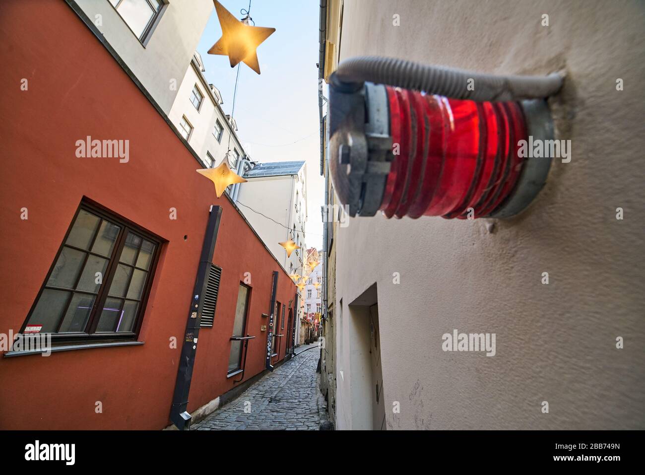 Red alert bulkhead light fixed to a painted yellow orange colour wall ...