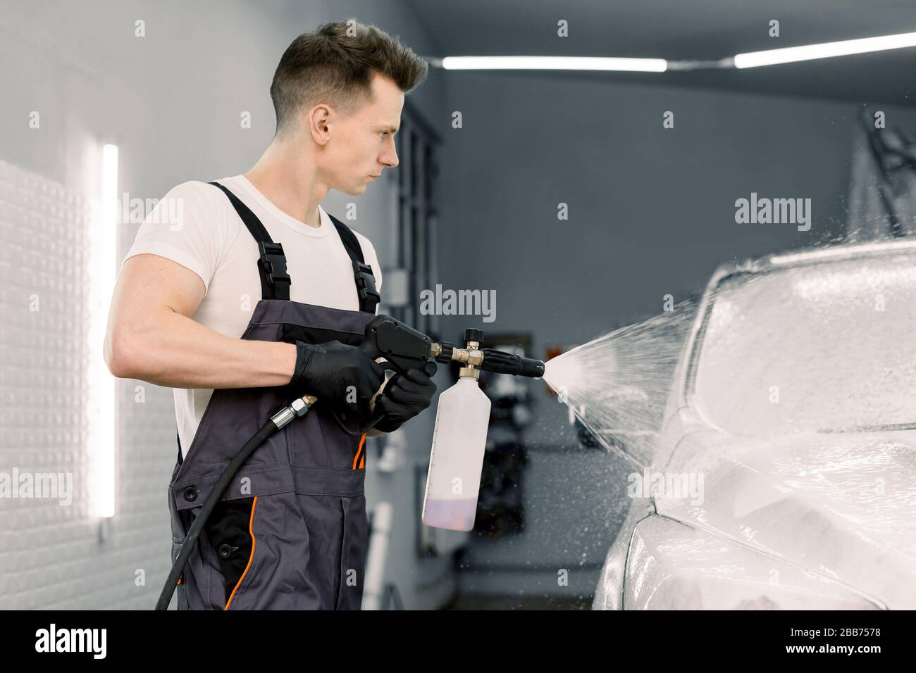 Car wash with flowing water and foam. Side view of young car wash ...