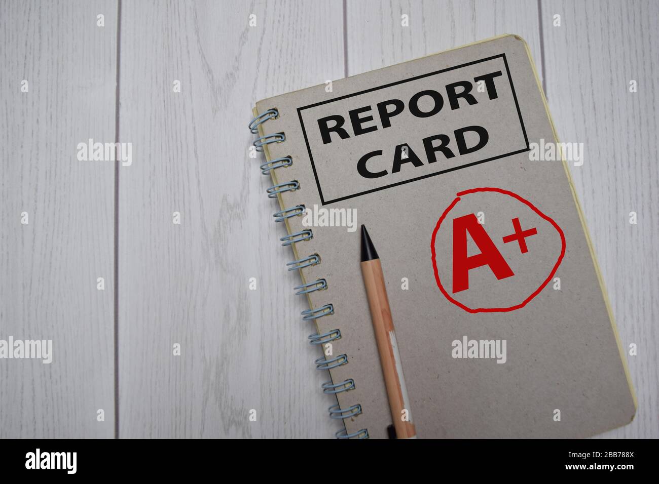 A plus - Report Card write on a book isolated on Office Desk Stock ...