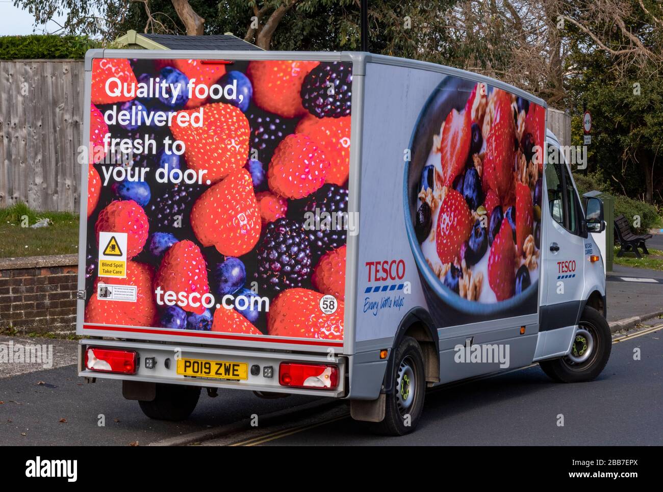 a tesco home delivery shopping van parked at the side of the road ...
