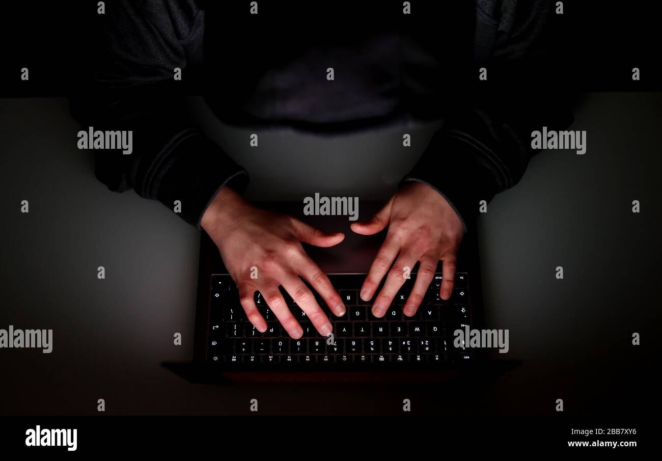 A laptop user with their hood up Stock Photo - Alamy