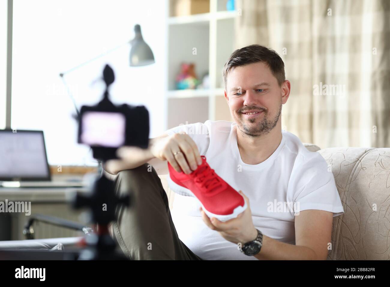 Guy front camera in apartment shows new sneakers Stock Photo - Alamy