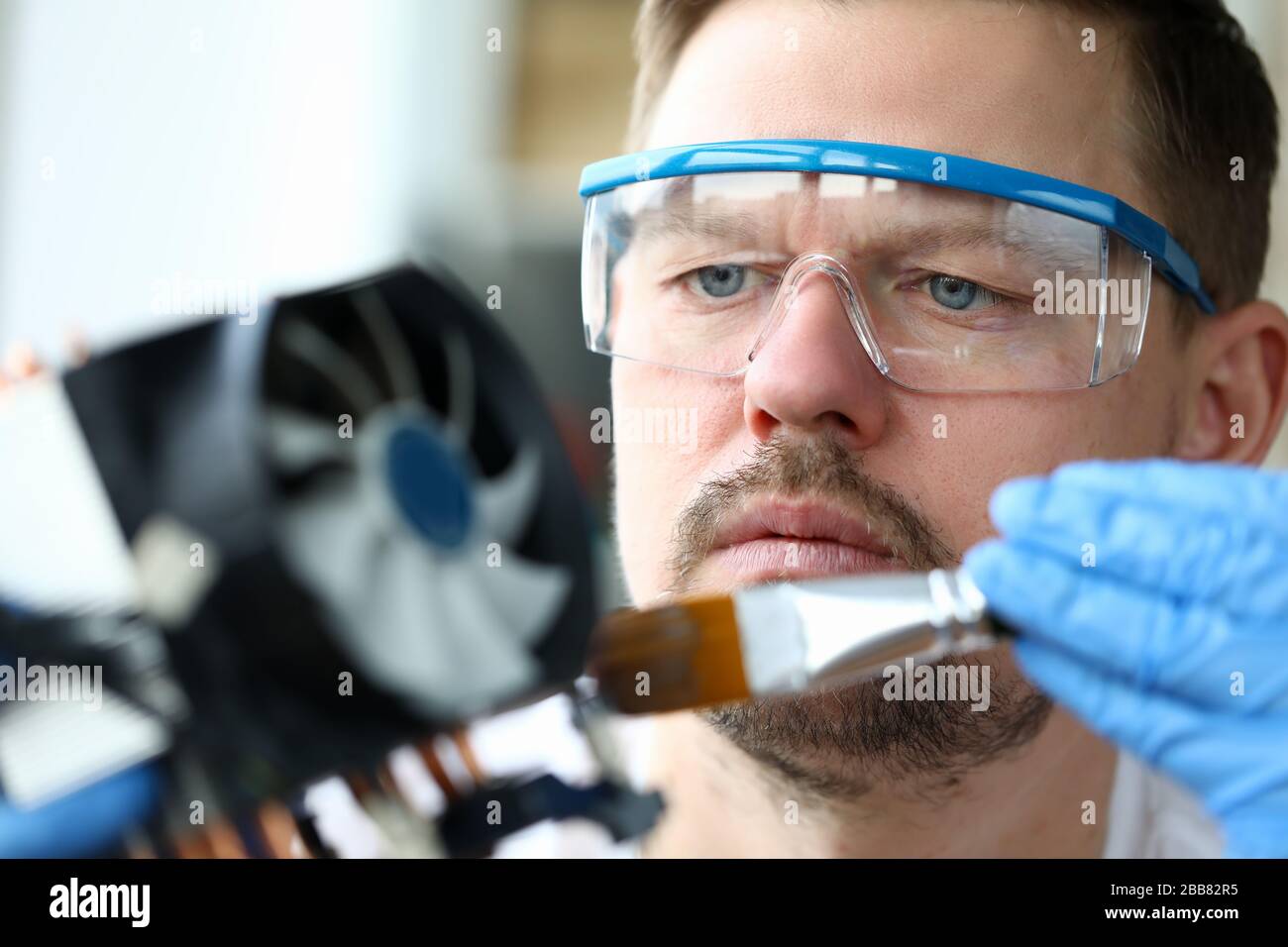 Close-up man goggles mends mechanical part device Stock Photo - Alamy