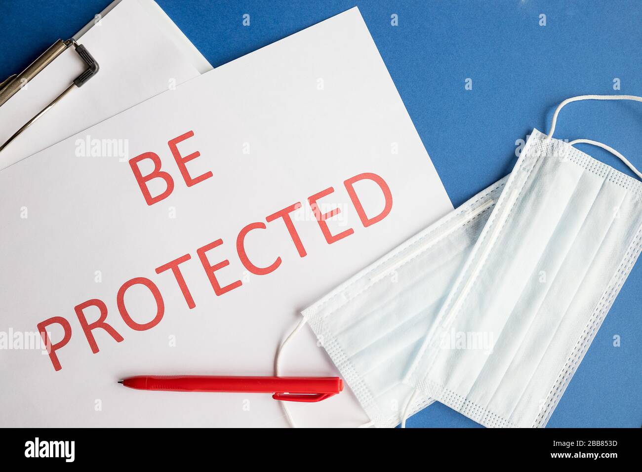 be protected text flat lay on blue background with pills, sanitizer and ...