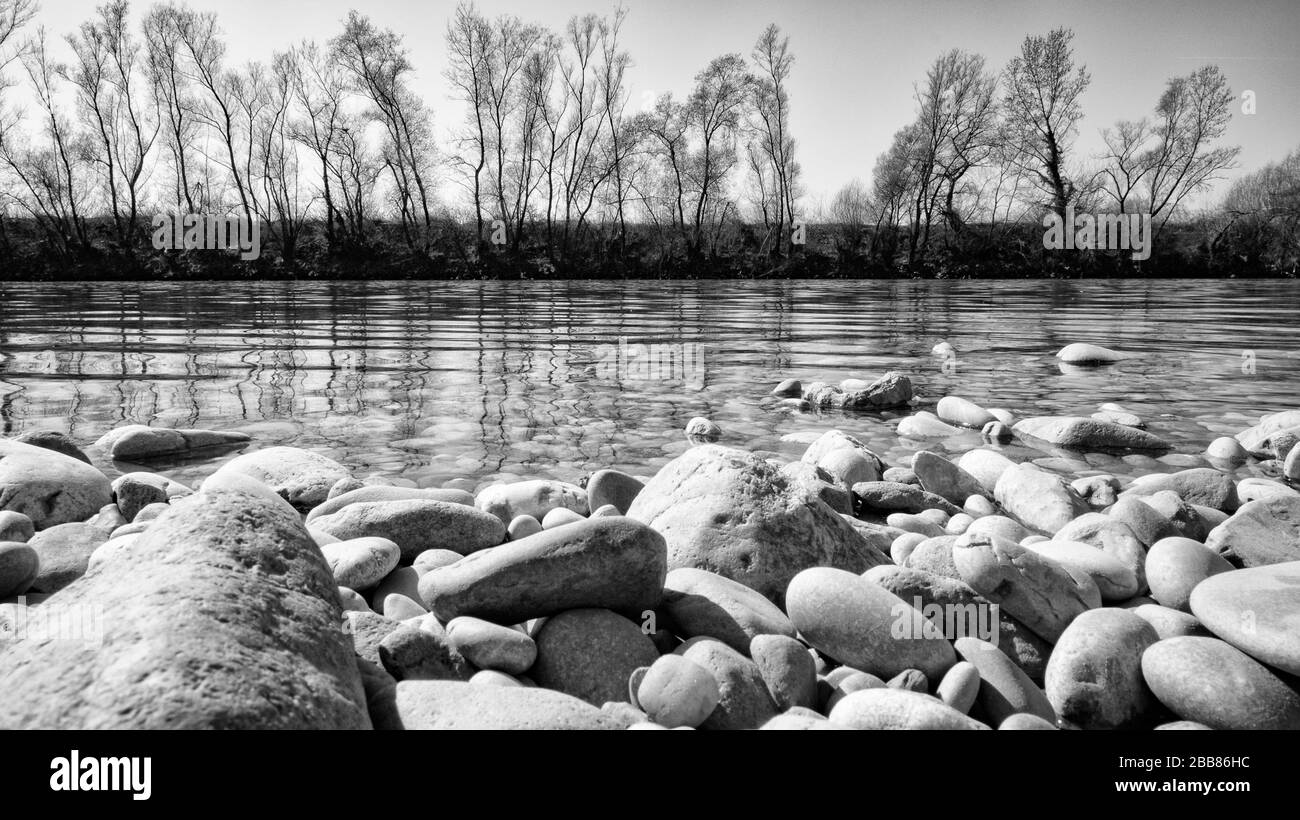 Slow Sava river flow on gravel beach, overlooking treeline on other ...