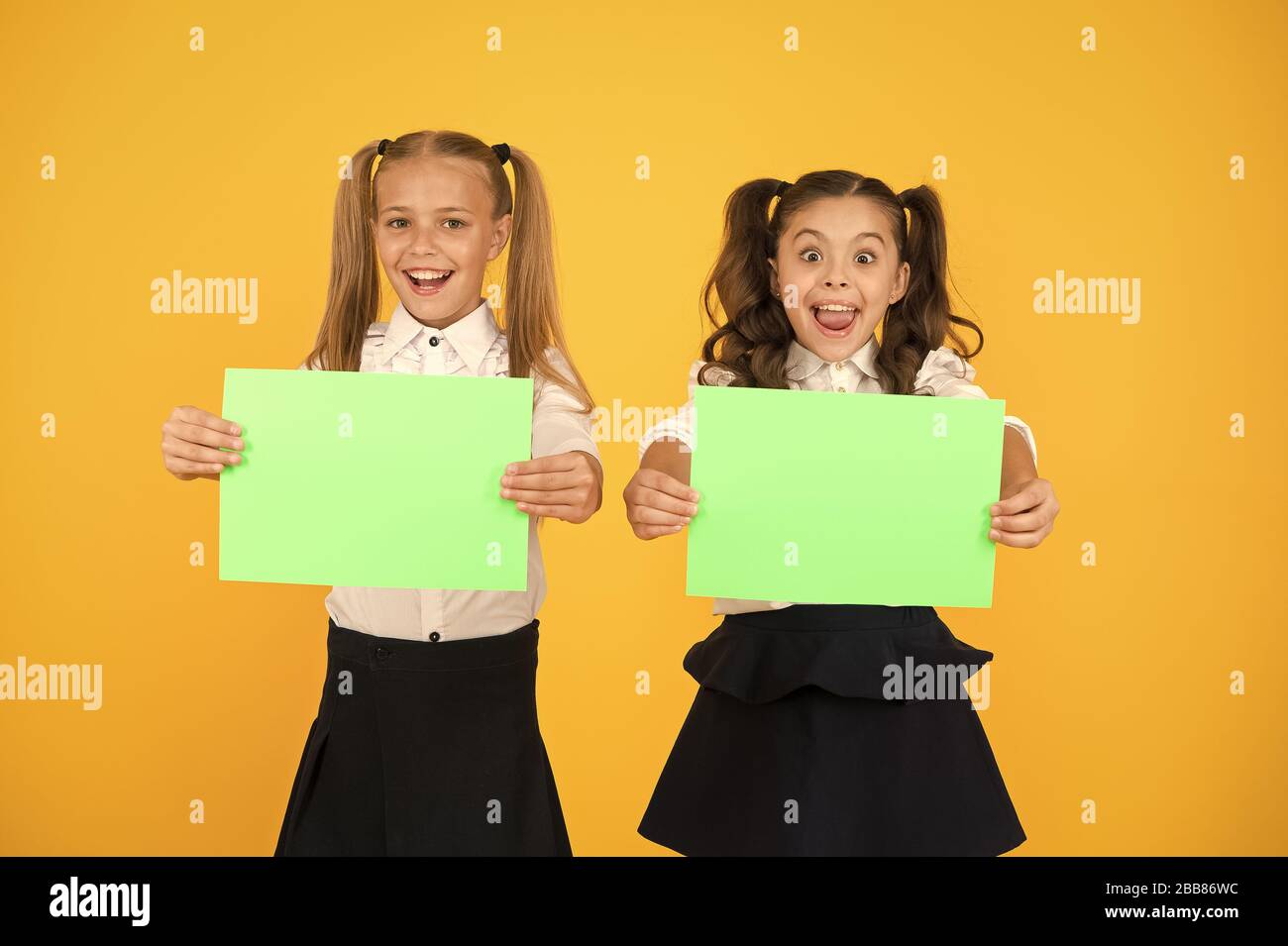 Advertising idea for school. Happy girls holding paper sheets for ...