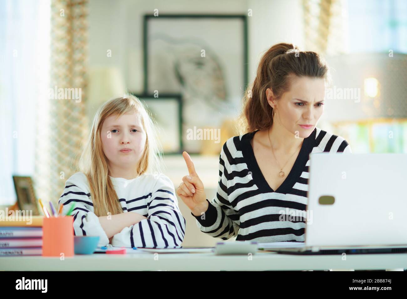 child craving attention while mother busy working in home office in the ...