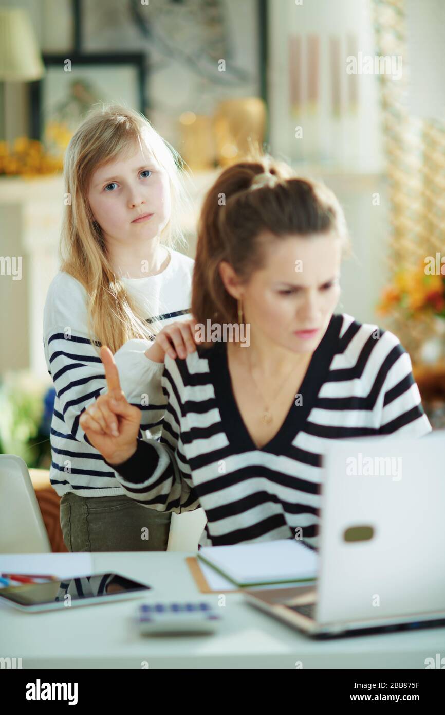 child craving attention while mother busy working in home office at ...