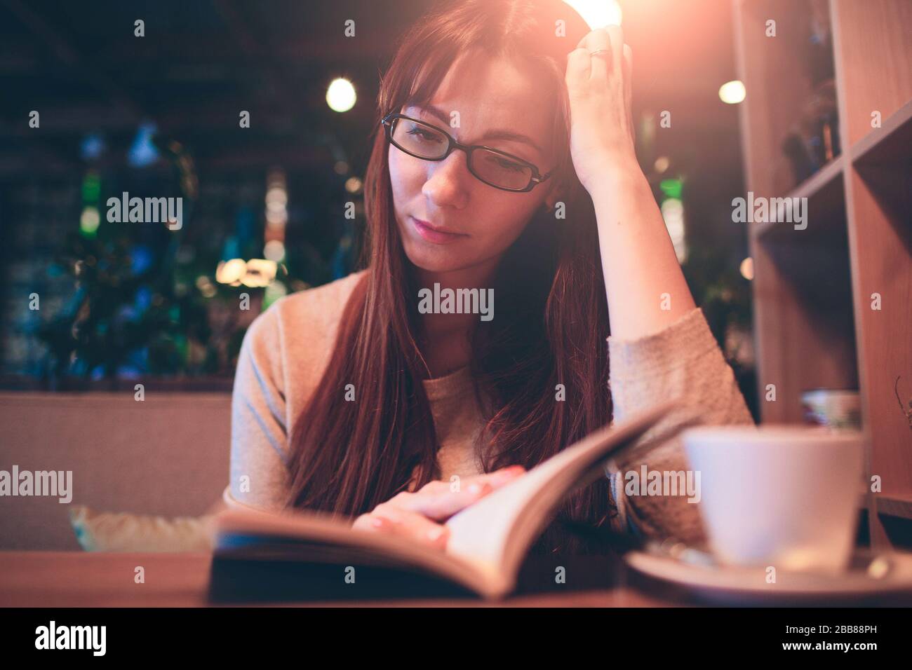 woman reading a book in a cafe Stock Photo - Alamy