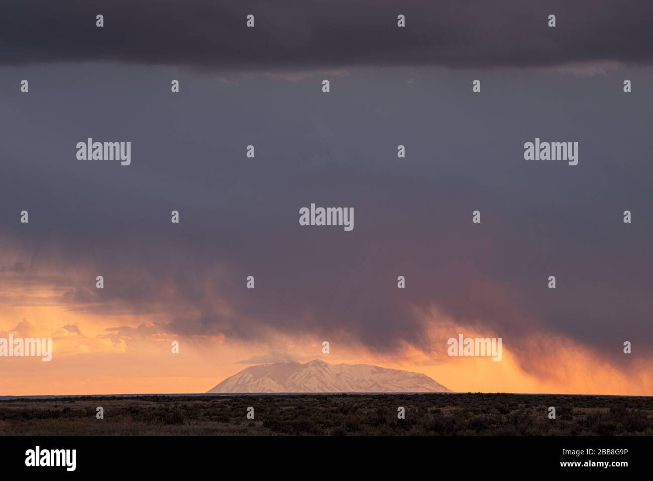 Spring storm clouds move over the Big Southern Butte, which is still ...
