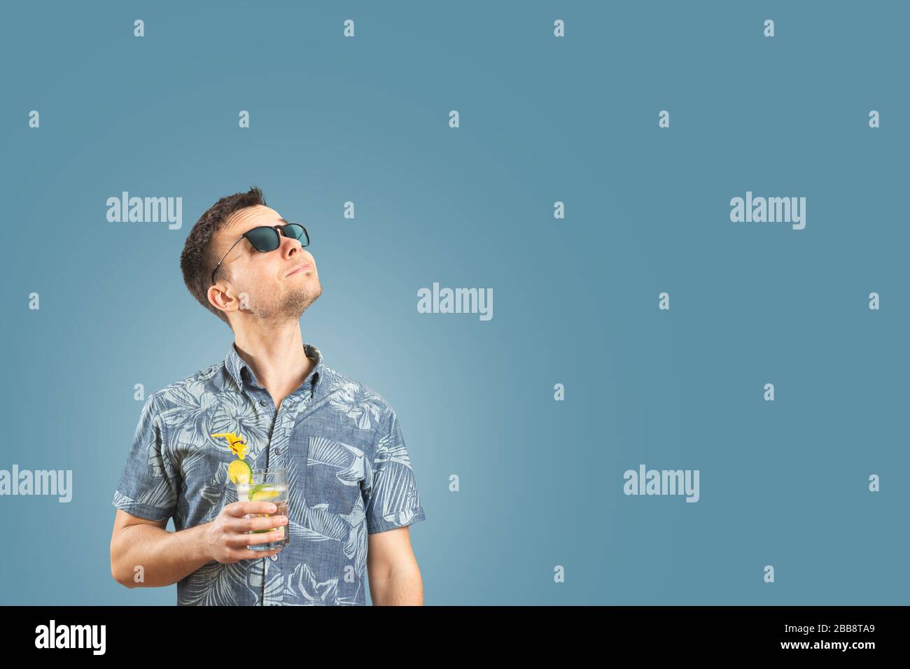 Tourist with a drink is looking upwards - isolated on blue Stock Photo ...