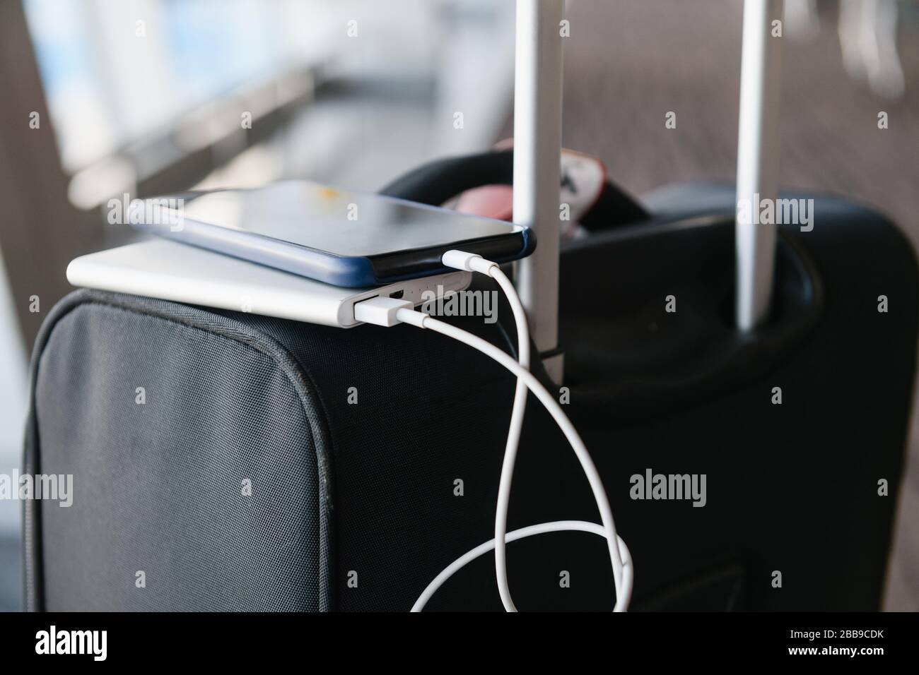 Smartphone charging from power bank on suitcase Stock Photo - Alamy