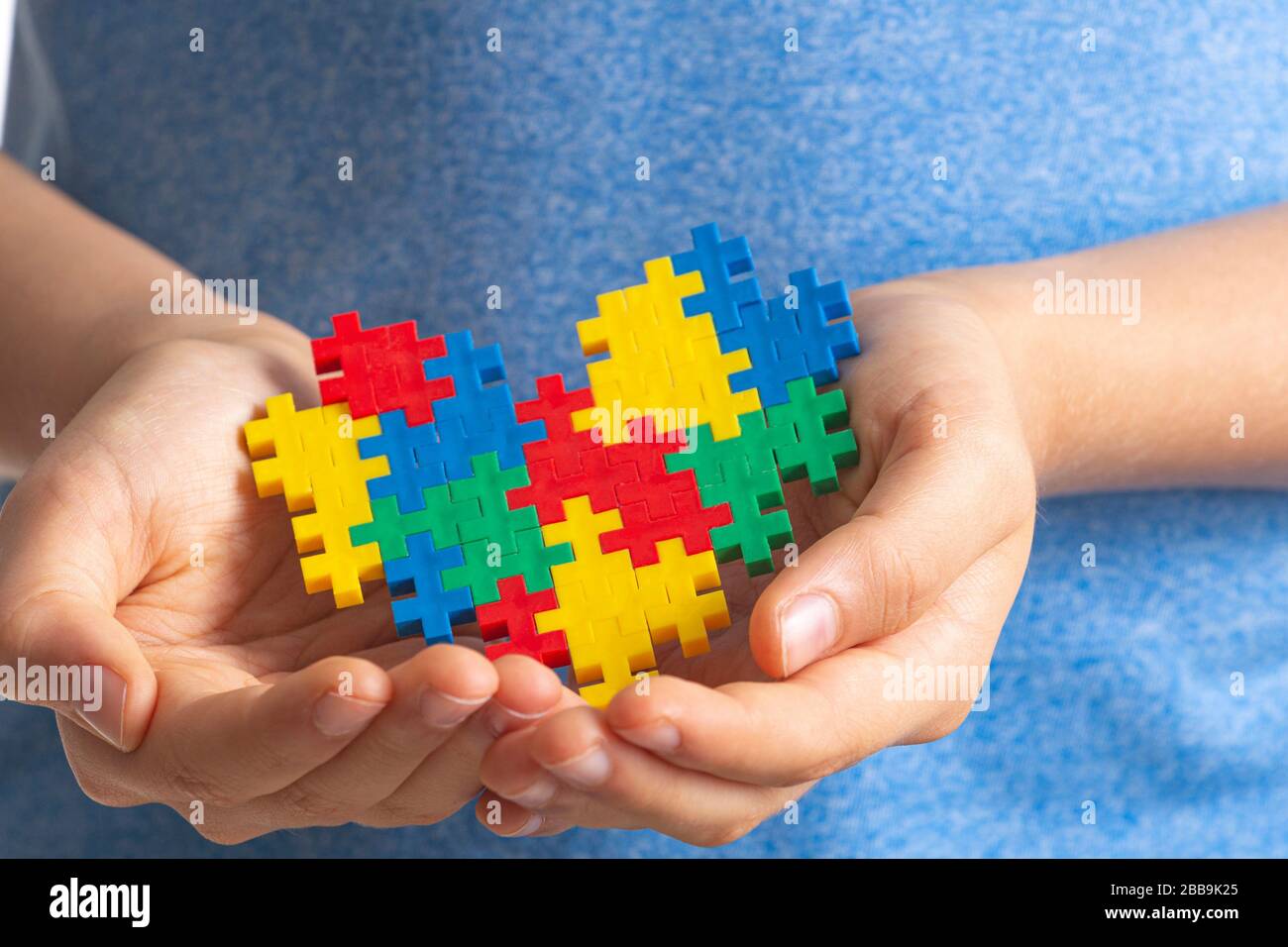 World autism awareness day concept. Child hands holding colorful puzzle ...