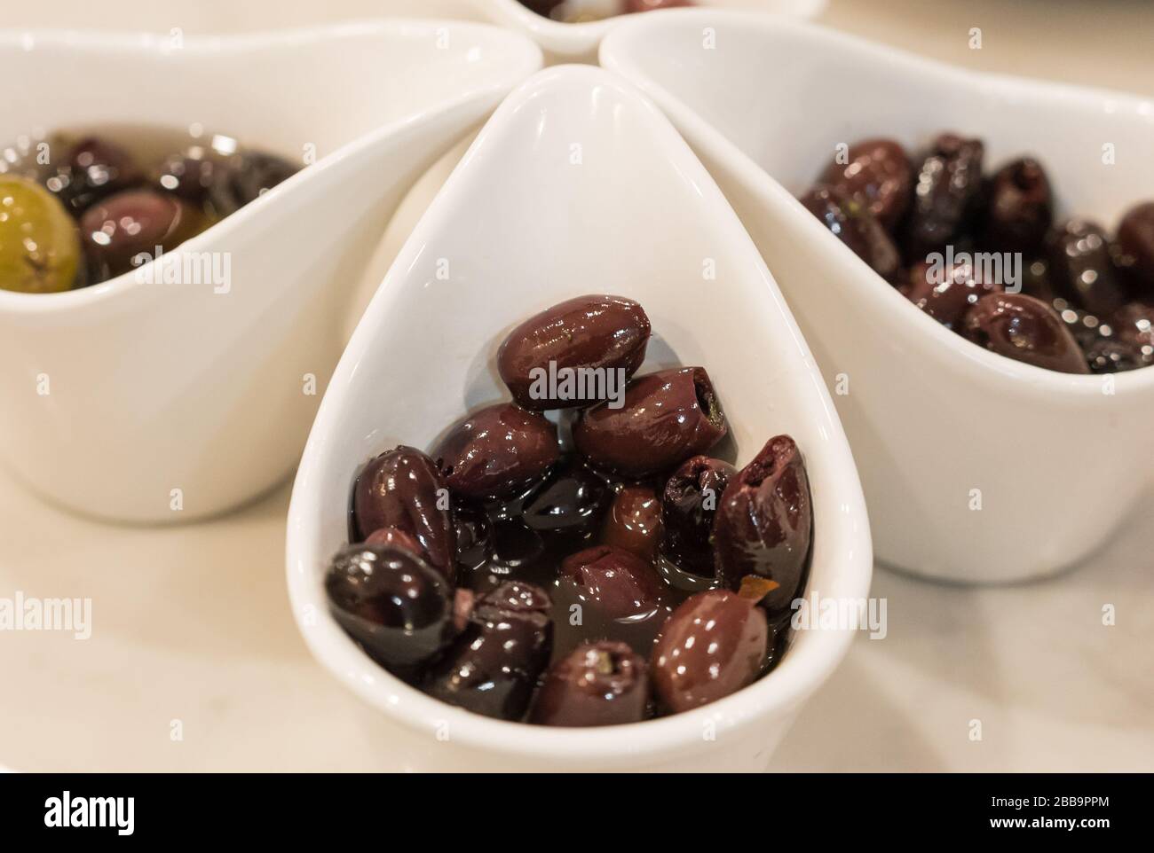 Close up of marinated olives in modern white bowls Stock Photo - Alamy