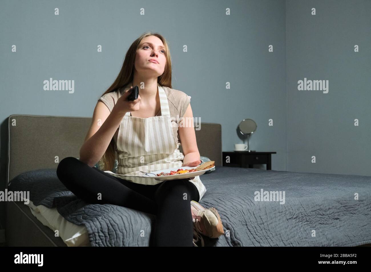 Homemade food on plate in hands of young woman, girl sitting on bed ...