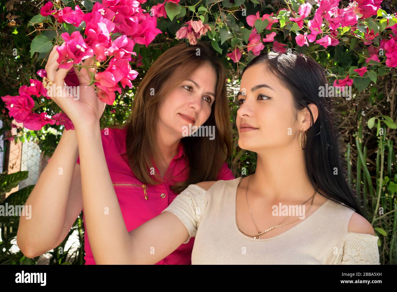 A middle aged cuban mother out in the garden with her beautifull young ...