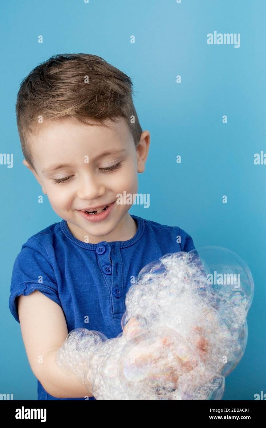 Child showing his hands with soap lather, cleaning and hygiene concept ...