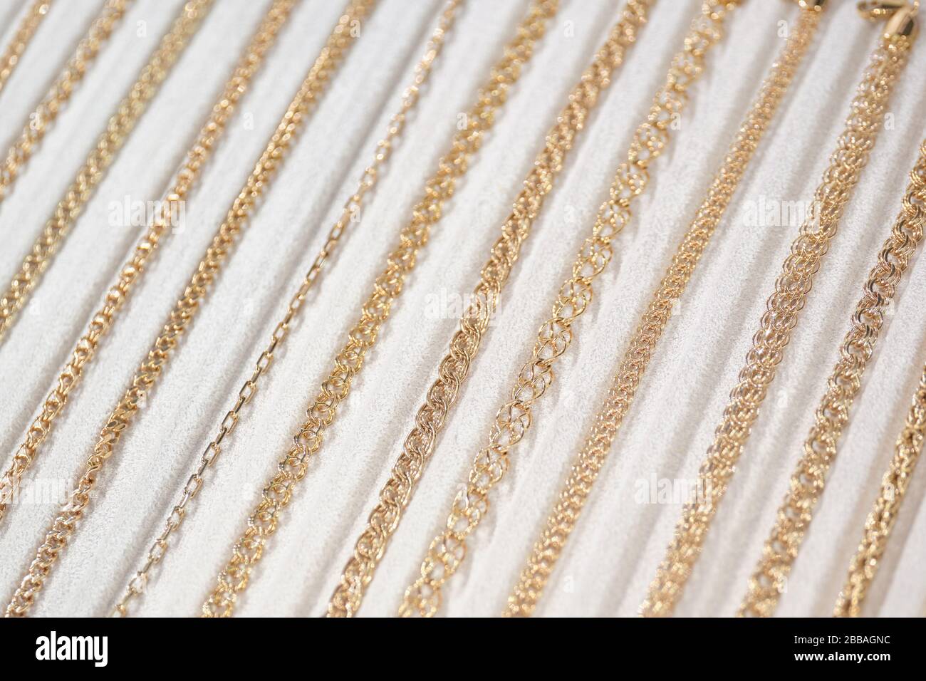 Gold chains and jewelry on a white counter. Close up Stock Photo - Alamy