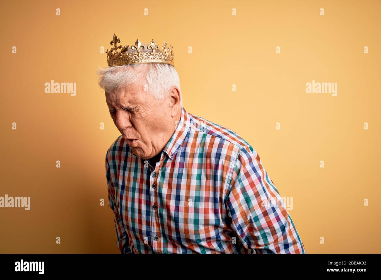 Senior handsome hoary man wearing golden crown of king over isolated ...