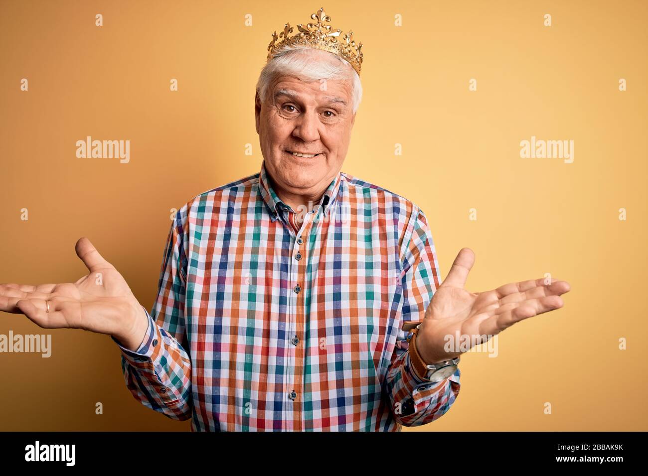 Senior handsome hoary man wearing golden crown of king over isolated ...