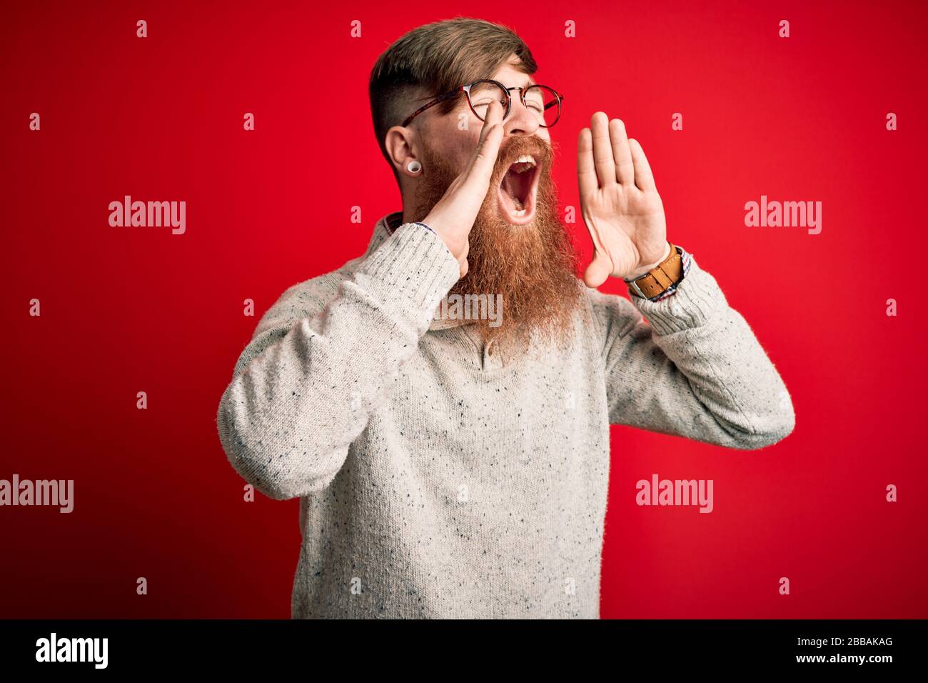 Handsome Irish redhead man with beard wearing casual sweater and ...