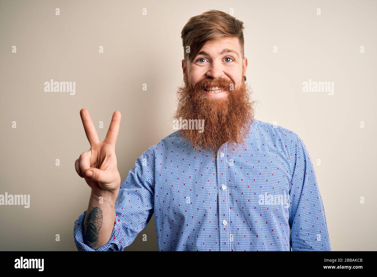 Handsome Irish redhead business man with beard standing over isolated ...
