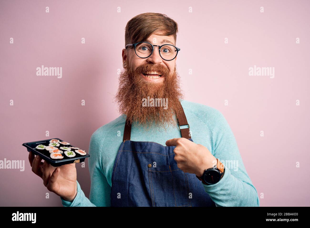 Redhead Irish cook man with beard holding maki sushi tray over isolated ...