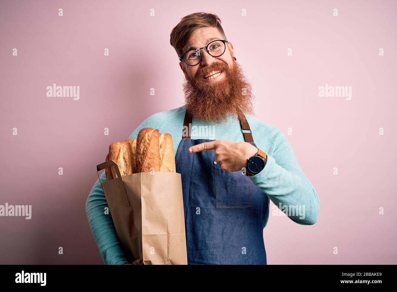 Irish redhead baker man with beard holding groceries paper bag of bread ...